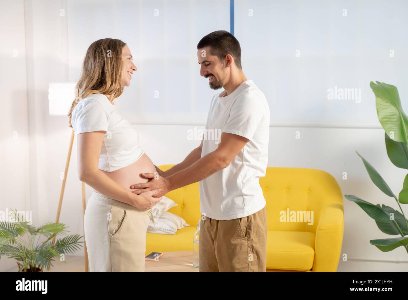 Pregnancy couple smiling happily touching belly Stock Photo - Alamy