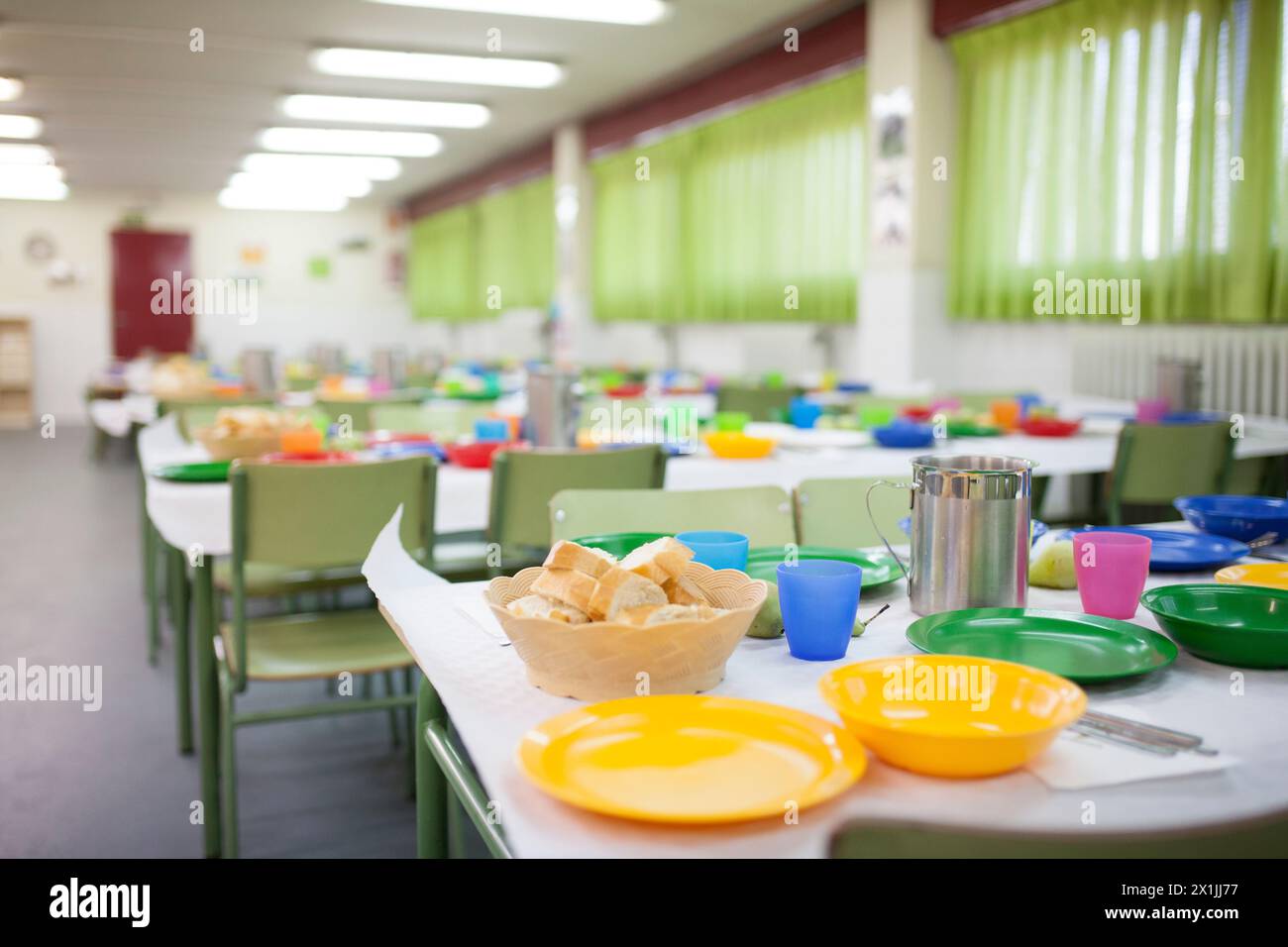 School dining room tables prepared for children to eat with glasses ...