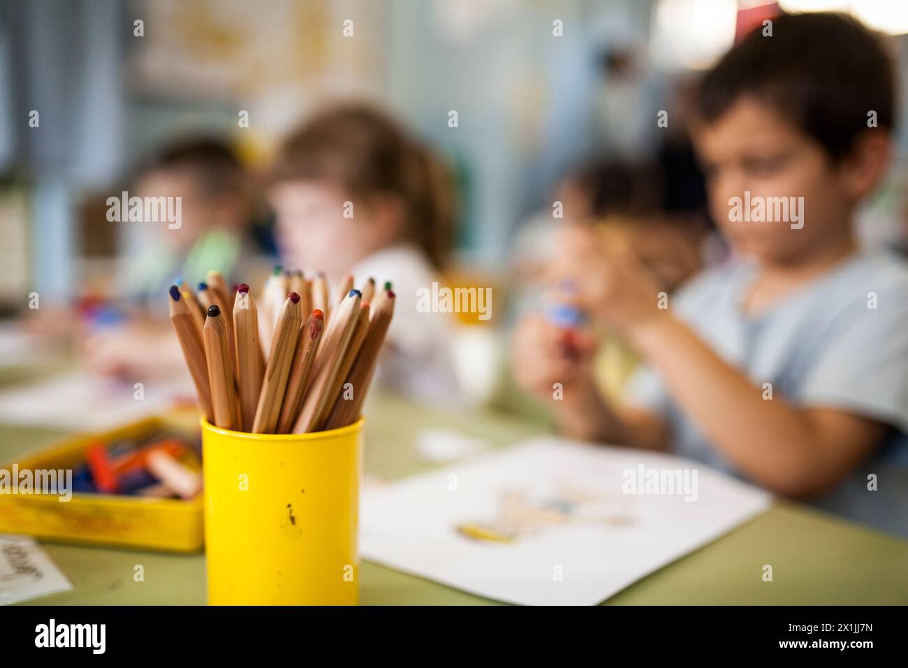 group of primary school children making a drawing with paintings on the ...