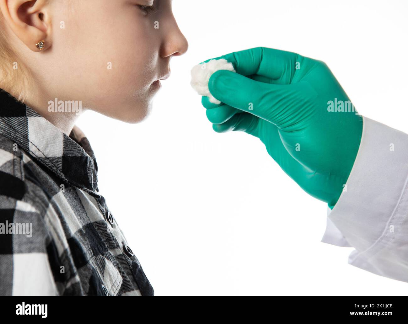 a doctor's hand in a medical glove holds a cotton swab with ammonia to ...