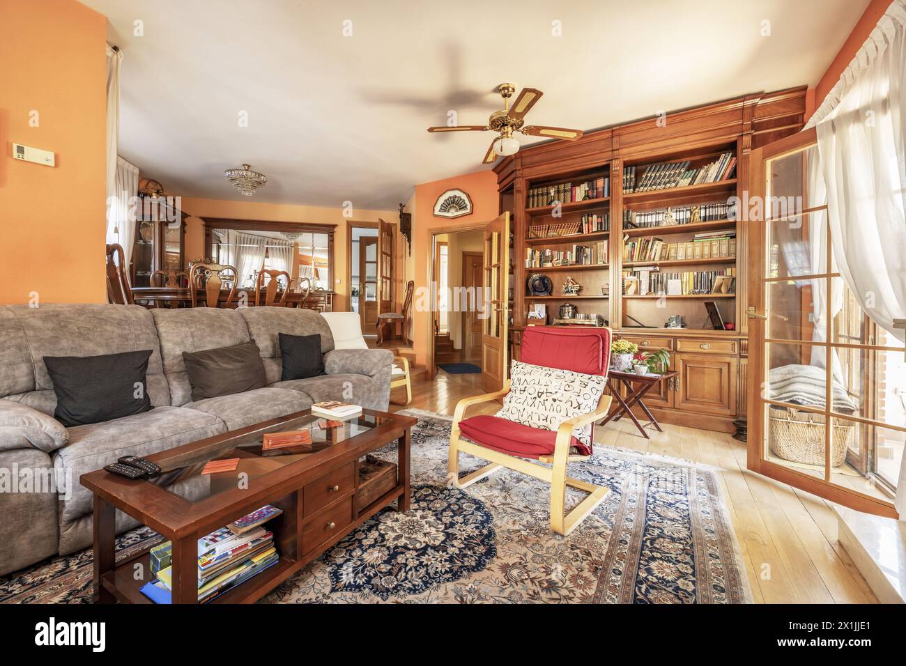 Two-story living room in a house with wooden furniture, a bookcase ...