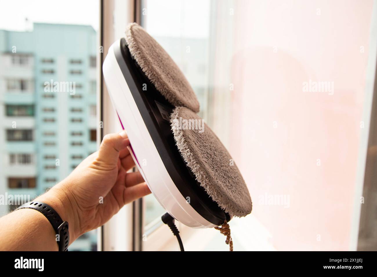 Connecting a vacuum window cleaner robot to a balcony frame Stock Photo ...