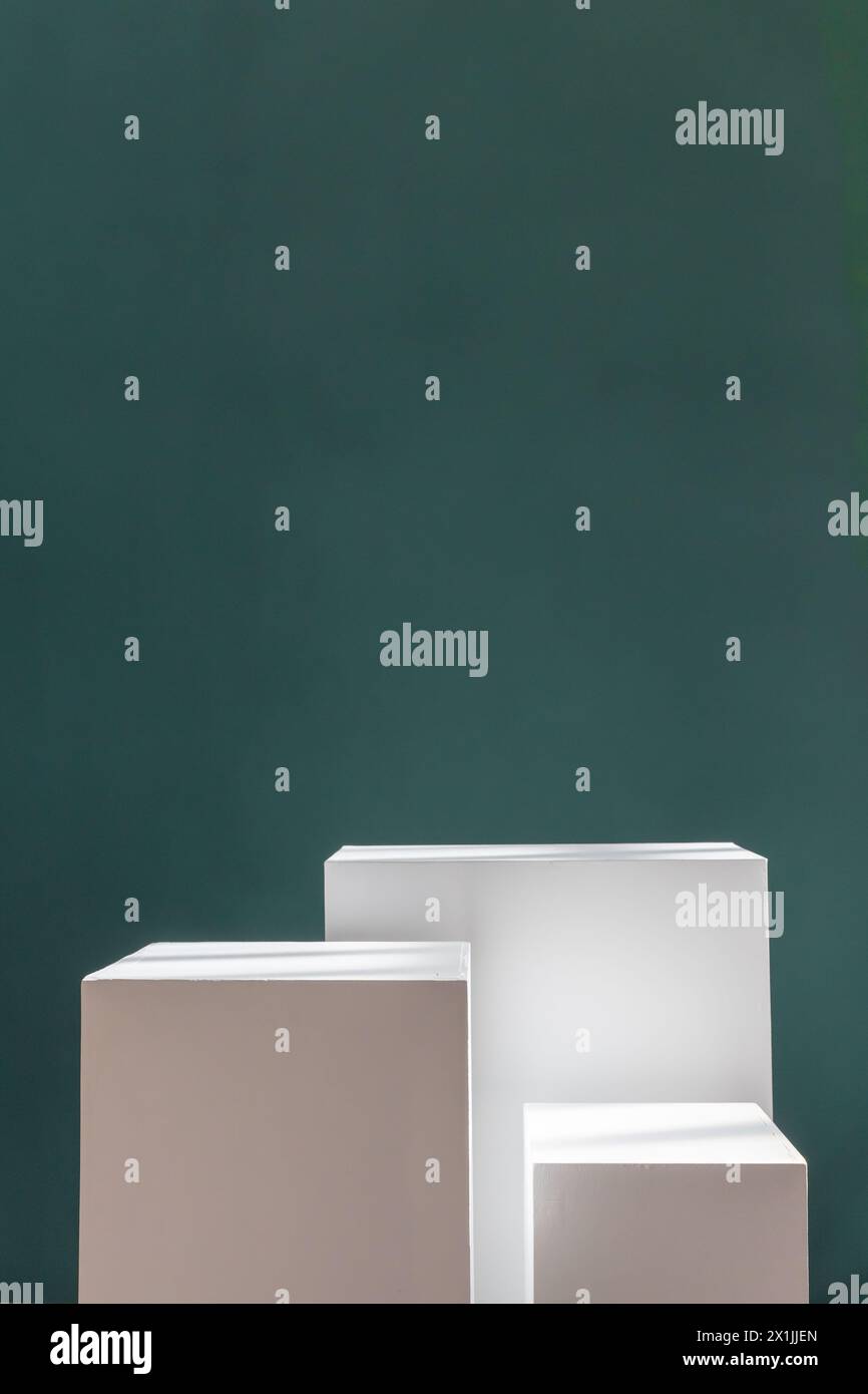 Three white rectangular boxes against a green wall. Product photography ...