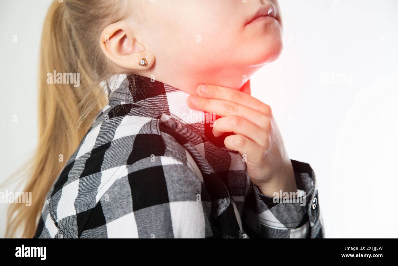 A blonde girl holds her sore red throat with her hands. Pain and ...