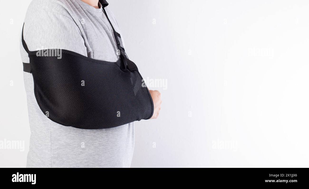 A man on a white background in a bandage to support his arm ...