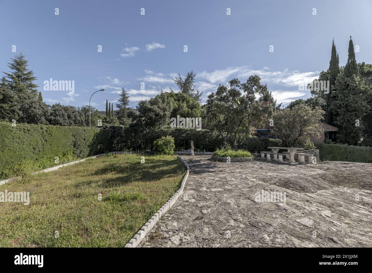 Large plot with unkempt grass and a lot of rock on the ground ...