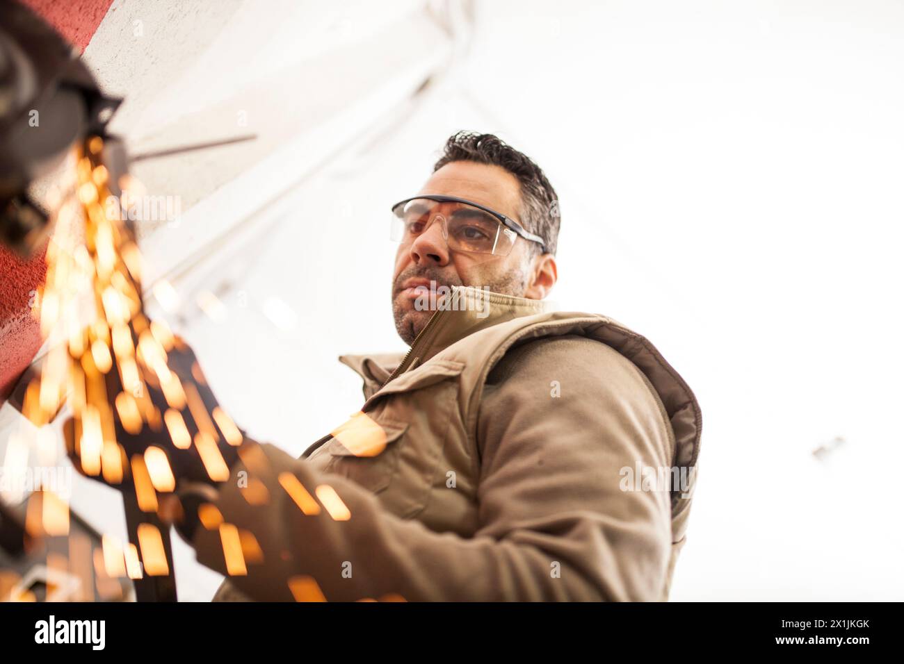 mechanical using the emery stone jumping sparks Stock Photo - Alamy