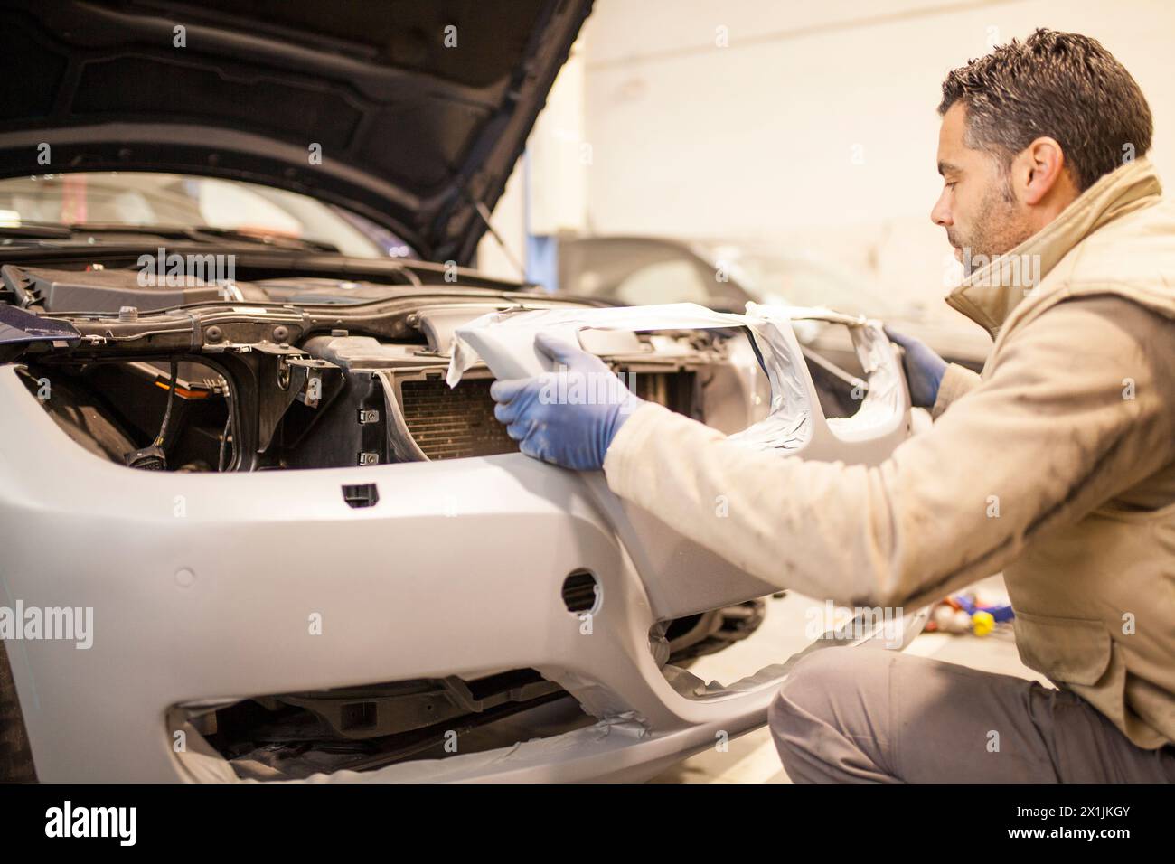 mechanic checks vehicle part in mechanic workshop Stock Photo - Alamy