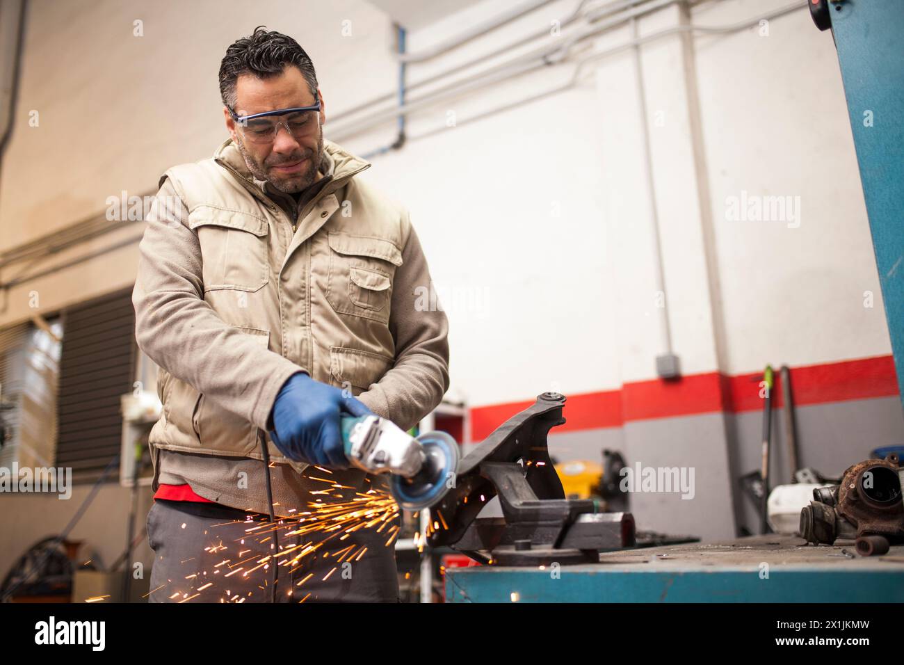 Mechanic man using grinder machine sparks in mechanical workshop Stock ...