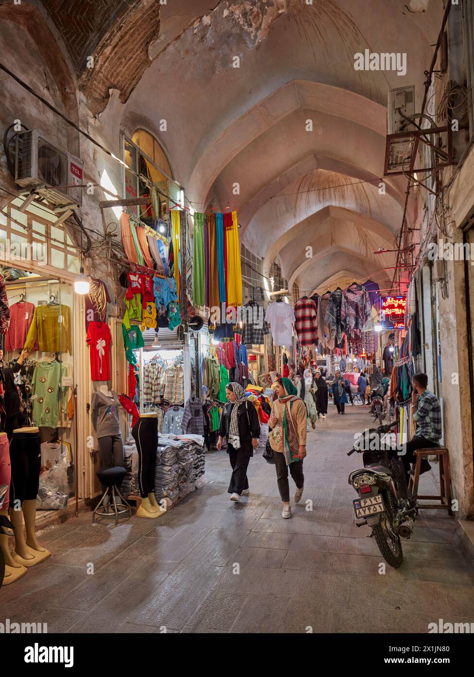 People walk in a narrow passage in the Grand Bazaar of Isfahan, Iran ...
