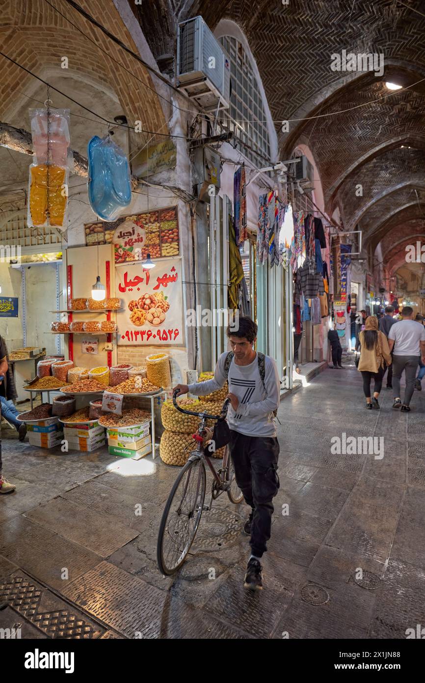 A young man walk with his bicycle in a narrow passage in the Grand ...
