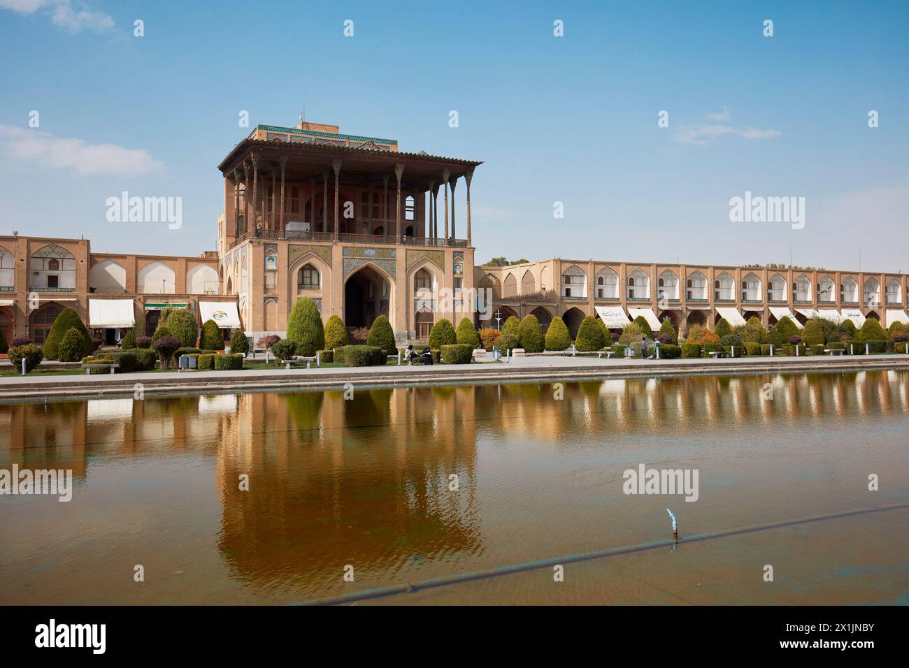 View of the Ali Qapu Palace and adjacent buildings reflected in a water ...