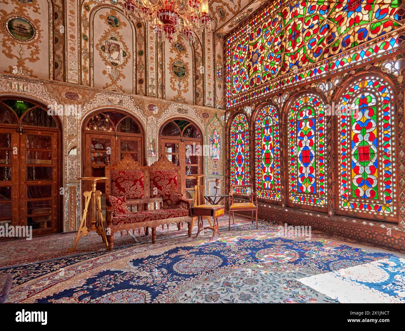 Ornate interior of the reception hall (shahneshin) with large colorful ...