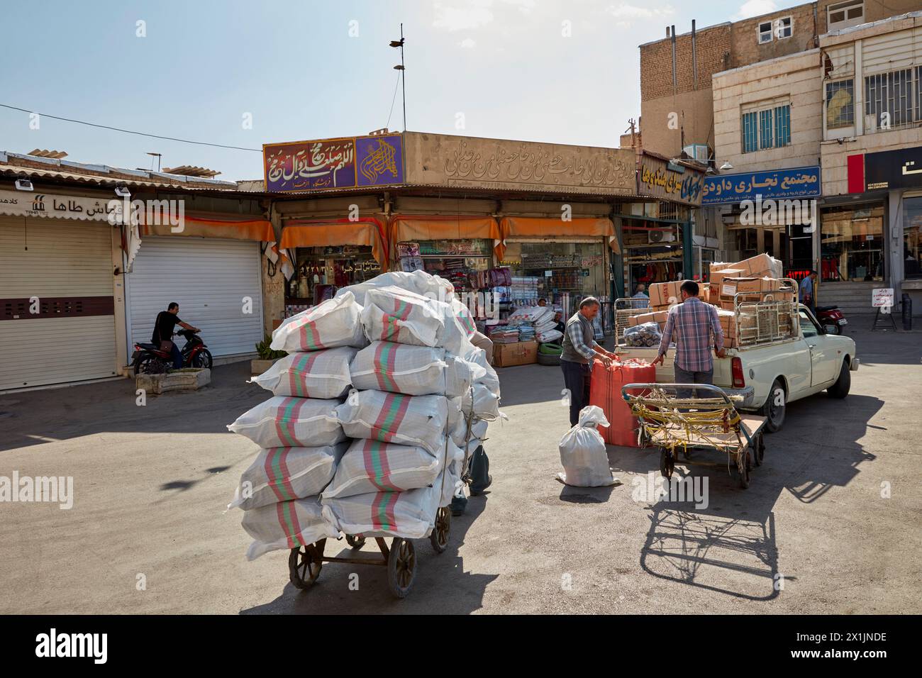 A porter pulls his heavily loaded cart in a street near the Grand ...