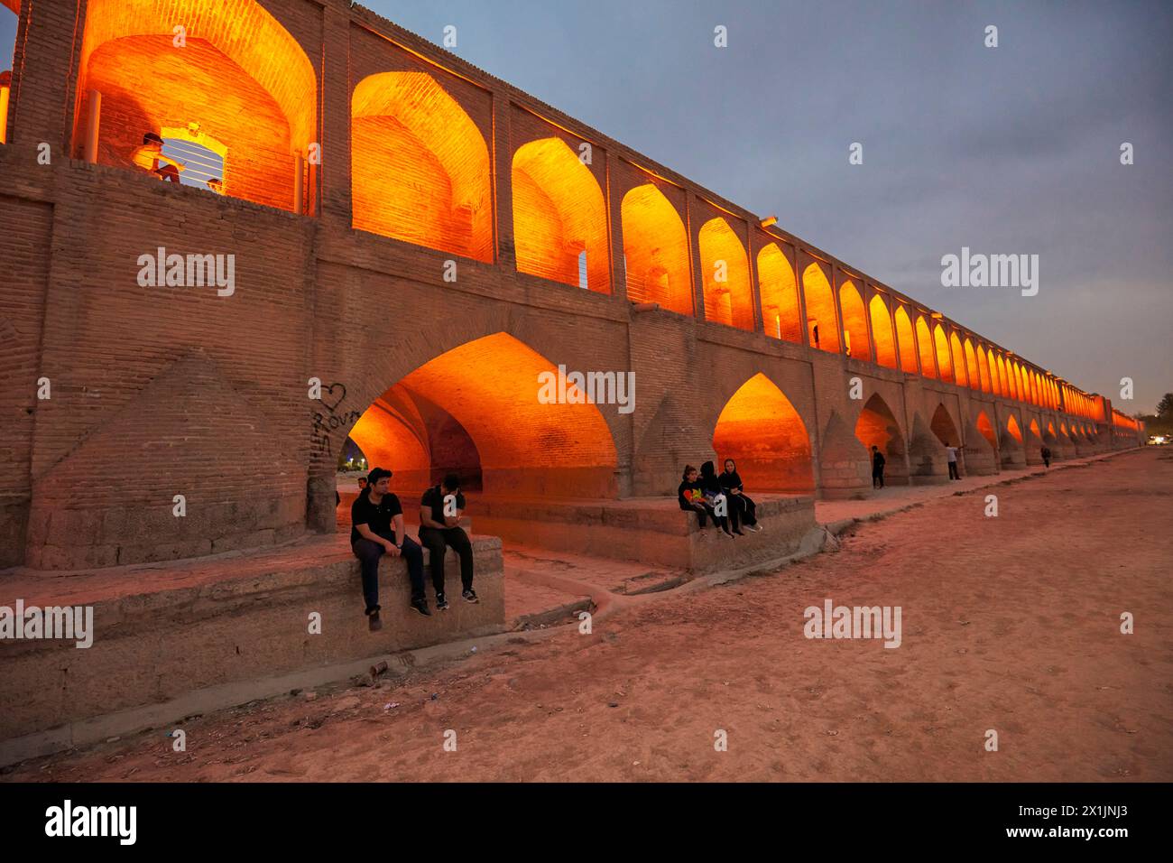 People sit on the Allahverdi Khan Bridge, aka Si-o-se-pol (17th century ...