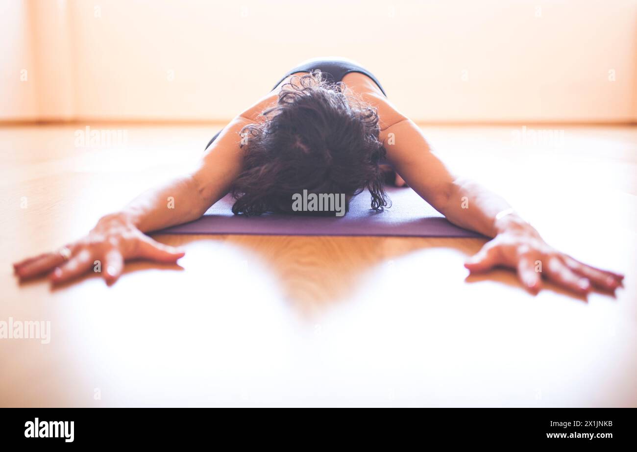 unrecognizable woman yogi lying face down with hands extended forward ...