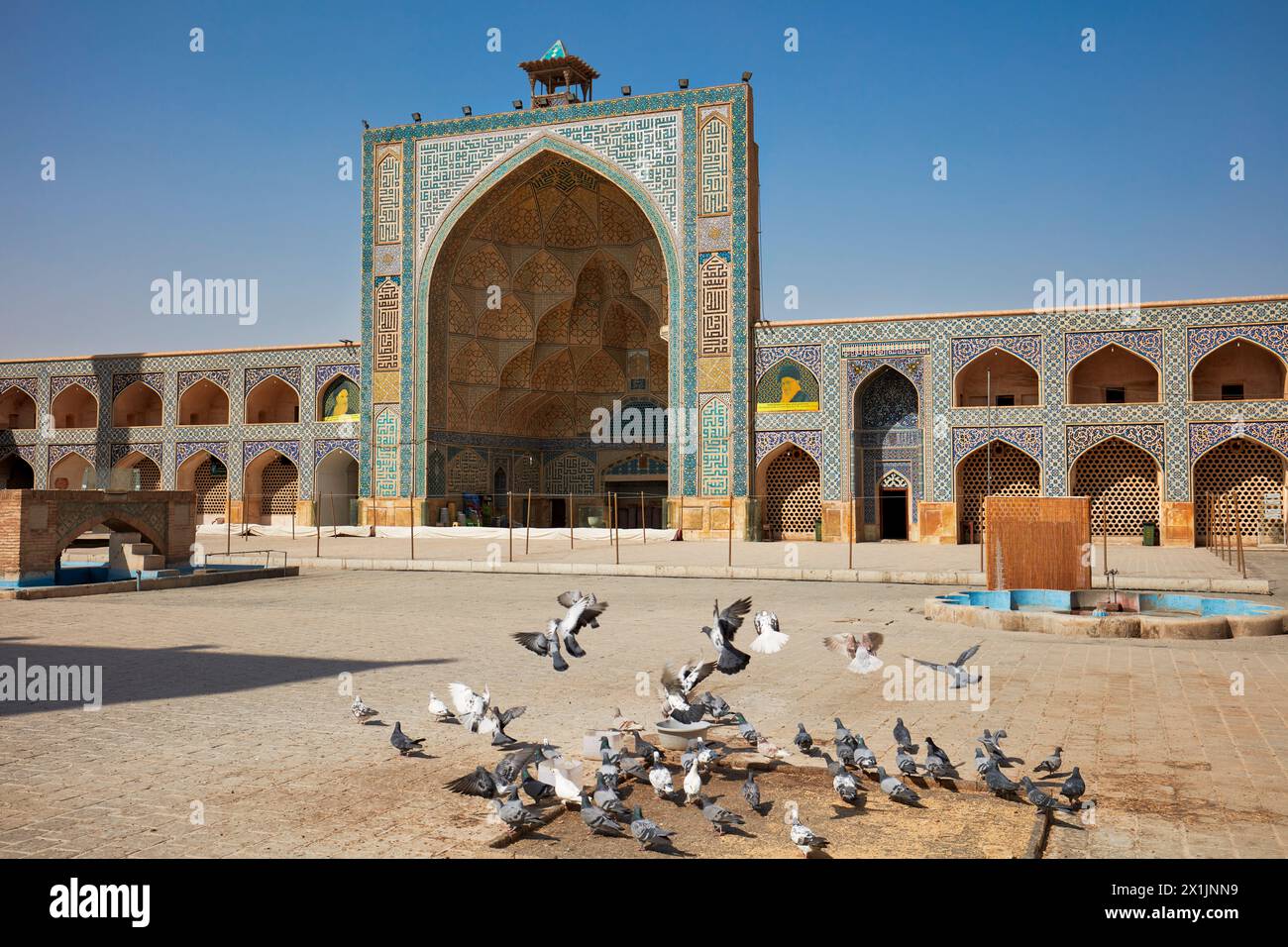 Pigeons feed in the courtyard of Jameh Mosque of Isfahan (8th cent ...