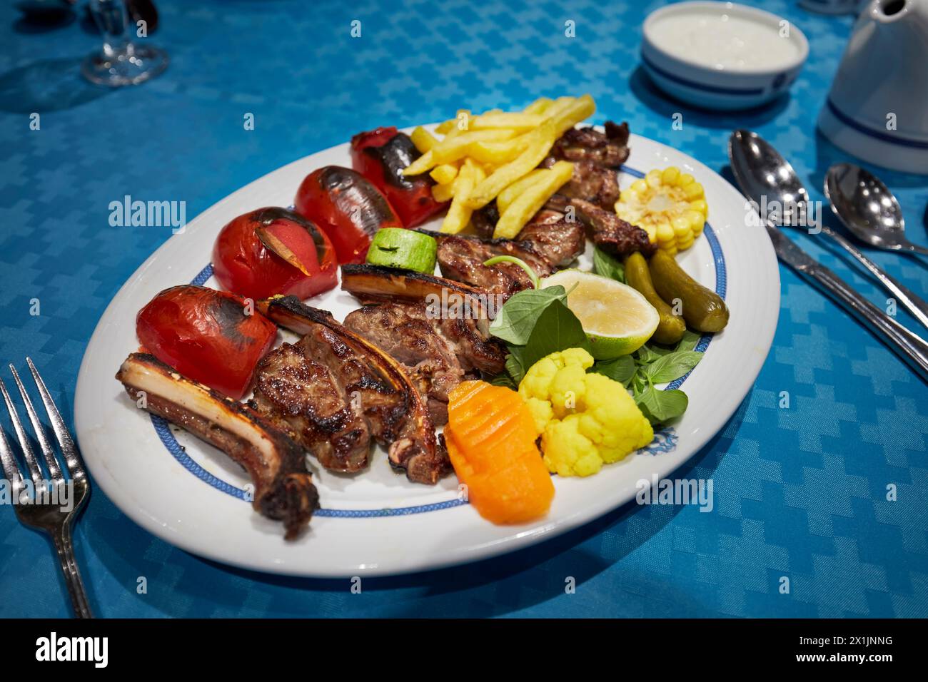 Kabab Shishlik (grilled lamb ribs) with vegetables served in a ...