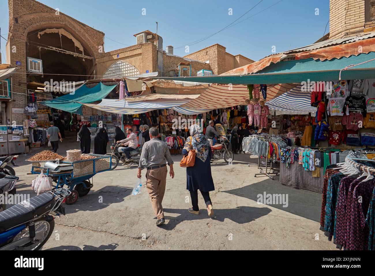 People walk in a street bazaar in the historic center of Isfahan, Iran ...