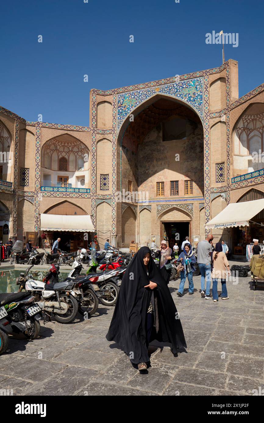 Iranian woman wearing traditional black chador walks at the Qeysarie ...