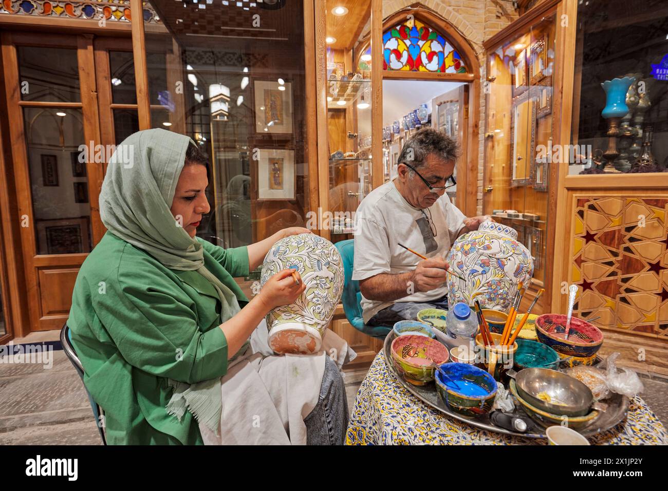 Iranian artisans hand paint large ceramic pots before final glazing ...