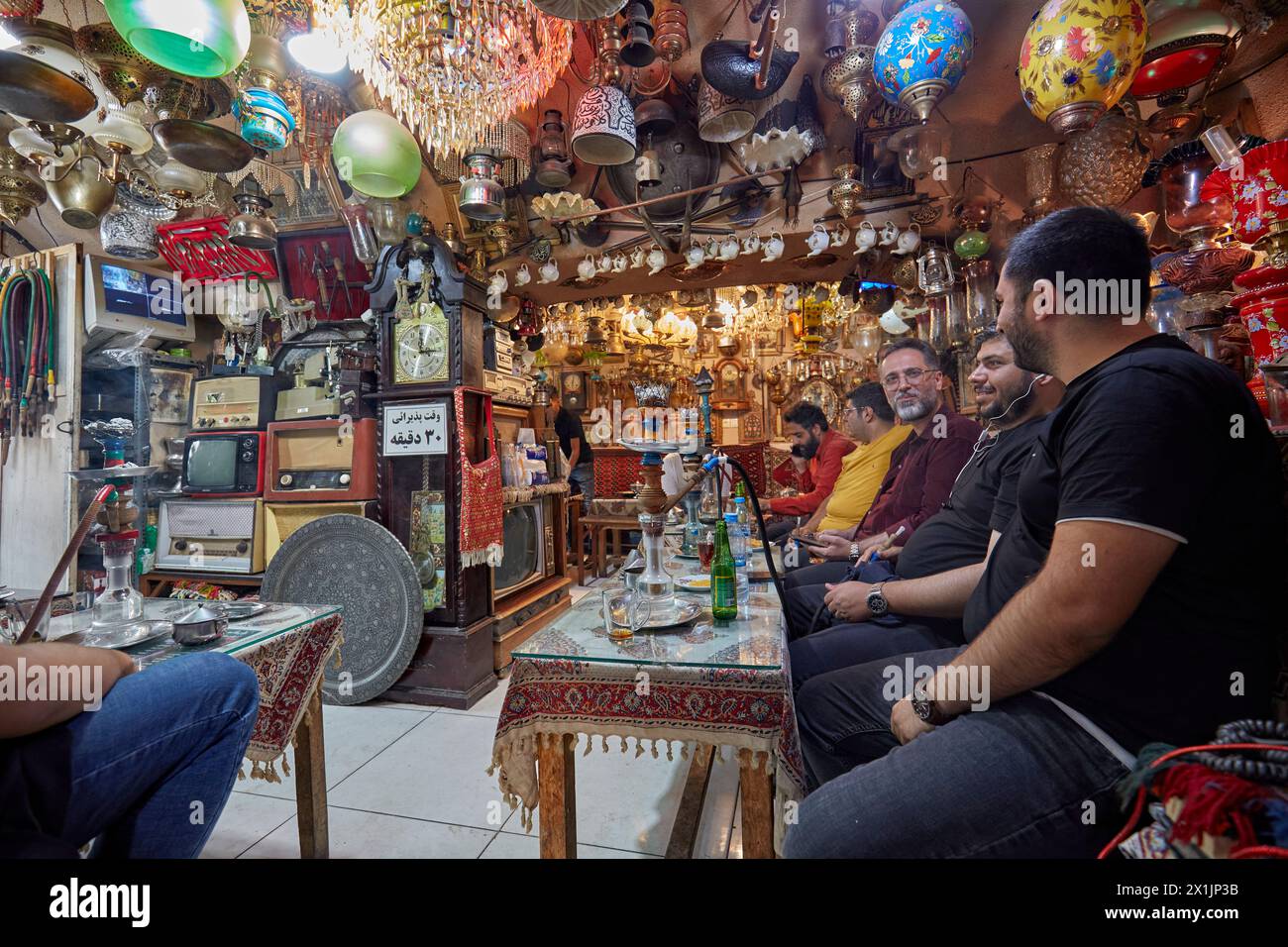 Iranian men sit together at a small table in Azadegan Cafe with its ...