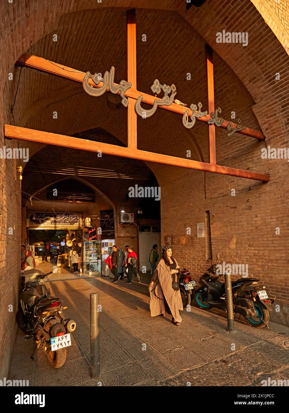 Young Iranian woman walks in an arched passage from the Grand Bazaar to ...