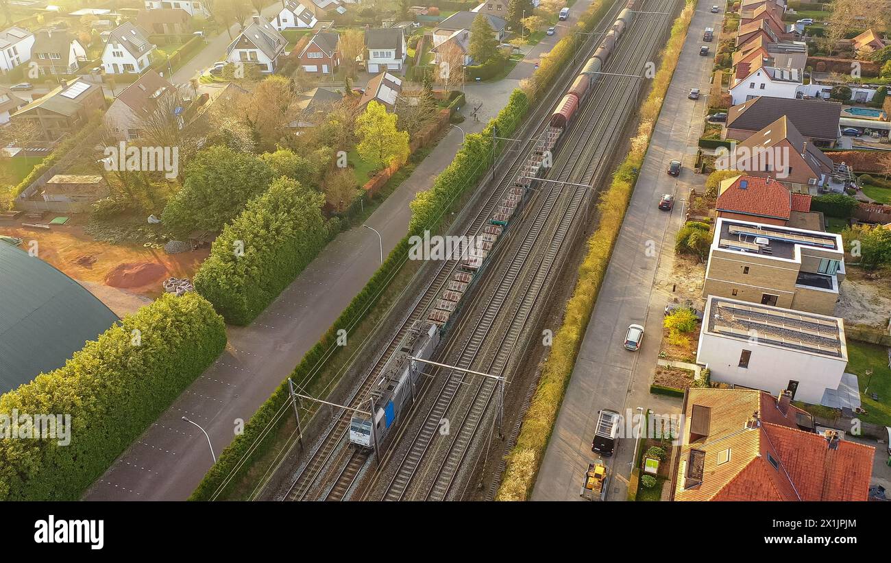 Aerial view of train running on track next to residential suburban ...