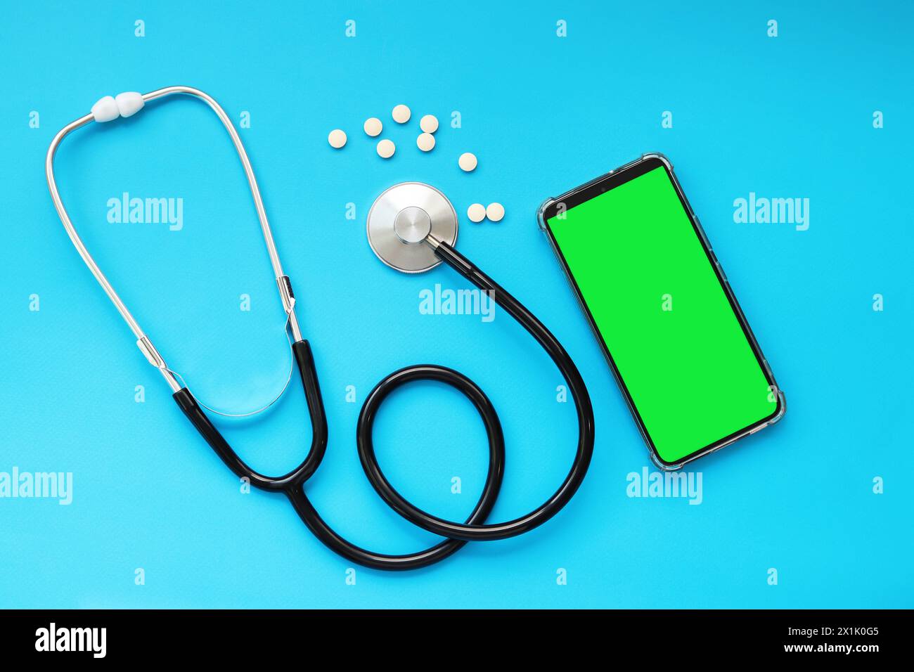 Stethoscope on a blue background and a smartphone with a green screen ...