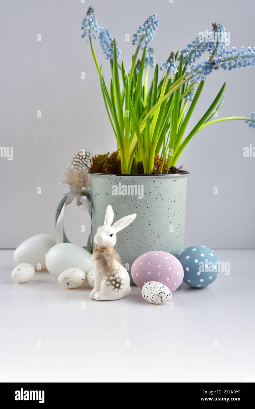 Easter composition with white rabbit, eggs and light blue muscari ...