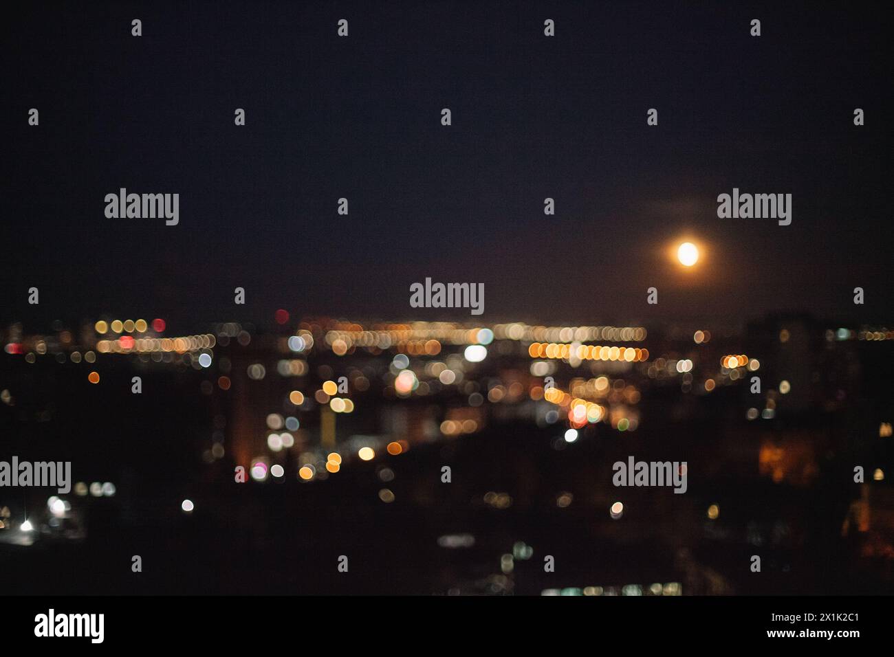 Defocused photograph of Moon over night city Stock Photo - Alamy