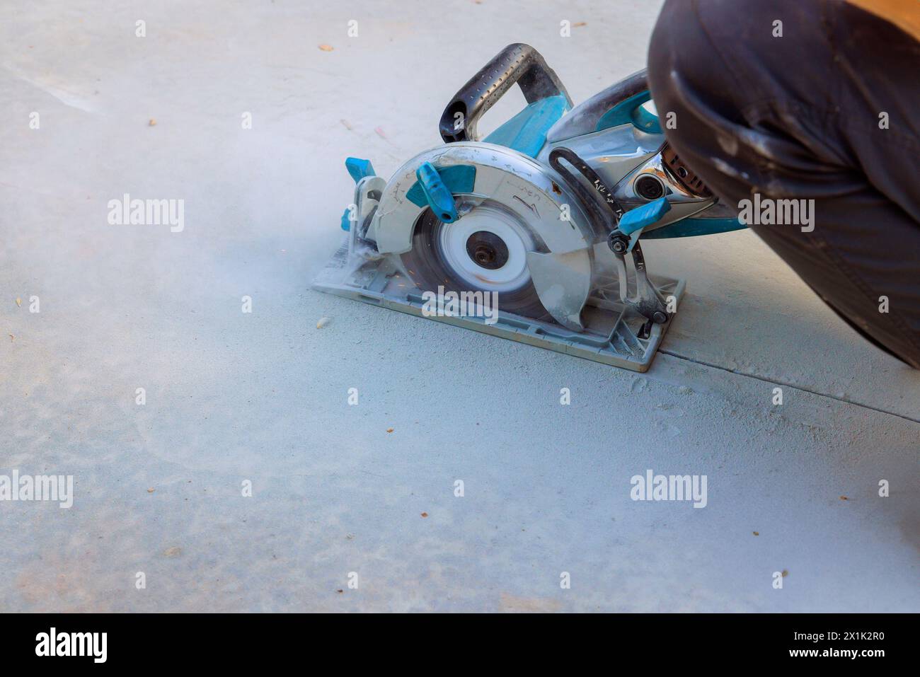Using cutting machine grinder, construction worker cuts concrete ...