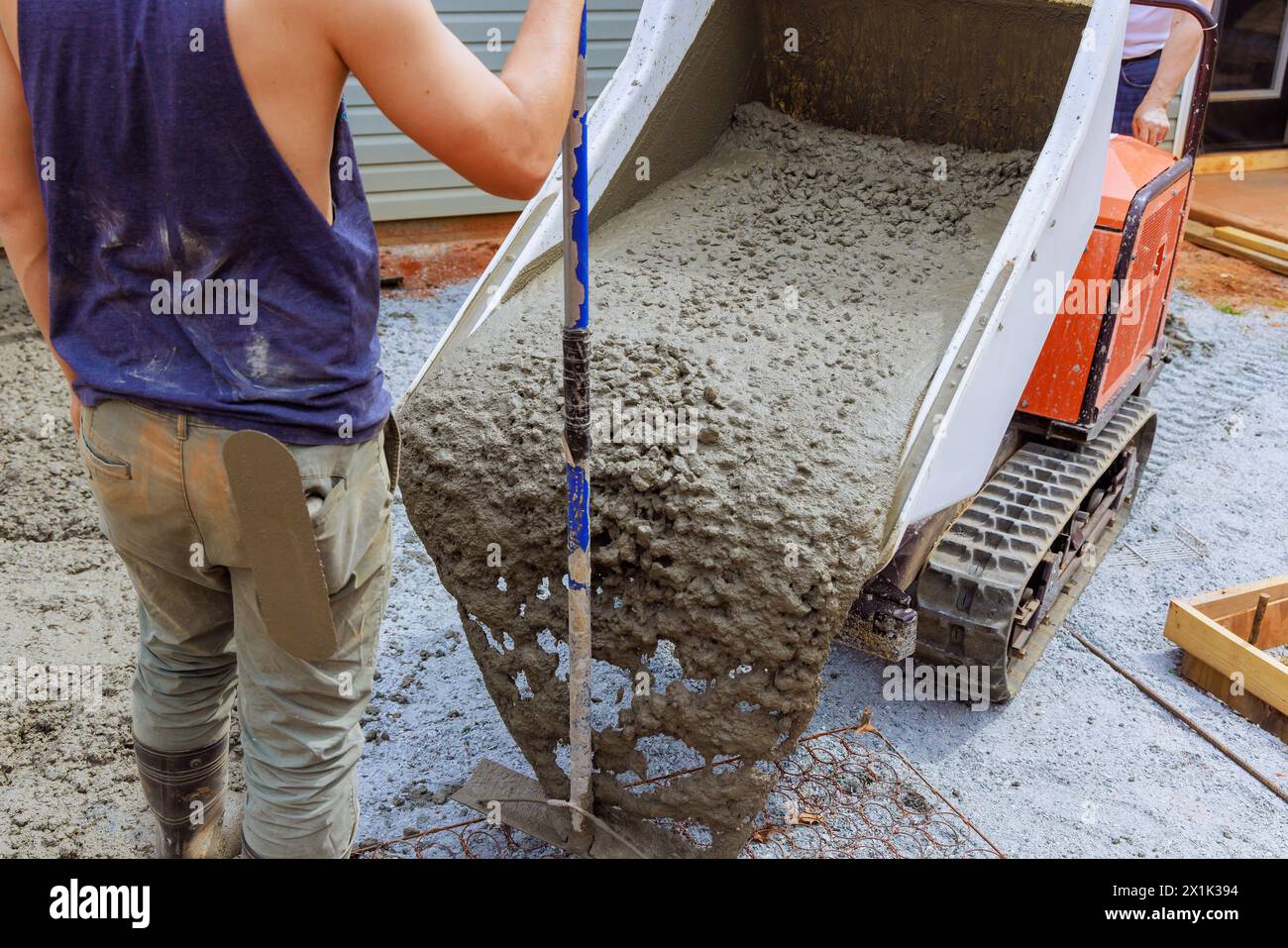 During construction of foundation, wet cement is poured into framework ...