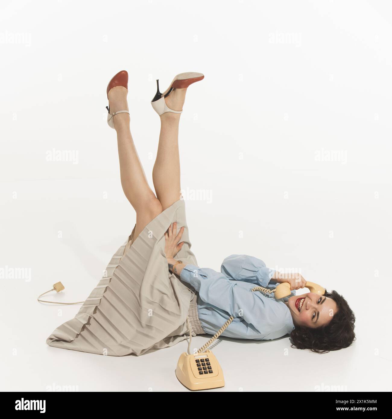 Happy, relaxed, positive young woman lying on floor and talking on ...