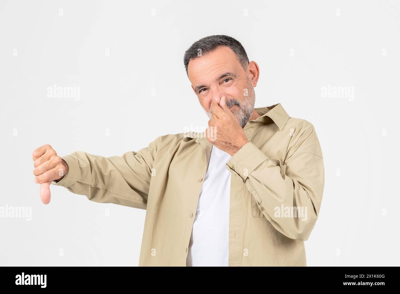 Senior man giving thumbs down with a smirk Stock Photo - Alamy