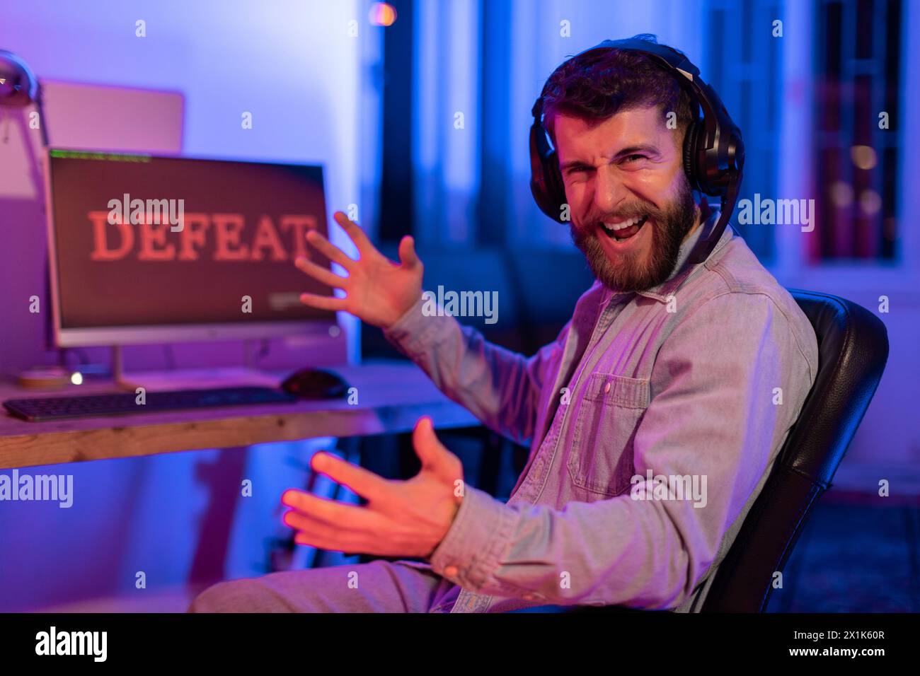 Frustrated guy at computer with 'defeat' sign Stock Photo - Alamy
