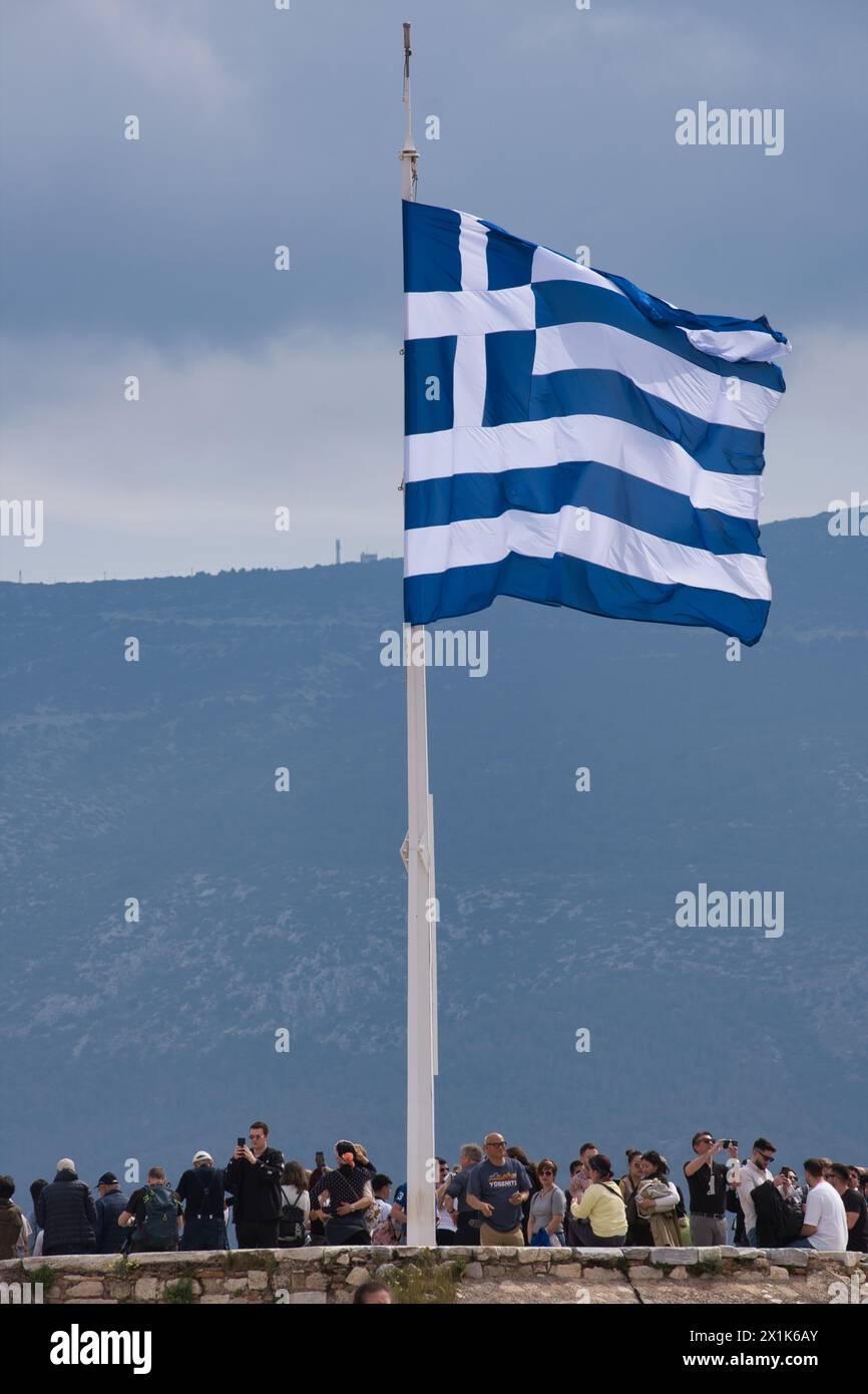 Tourists at the Greek Flag of Athens Acropolis on a stormy Spring day ...
