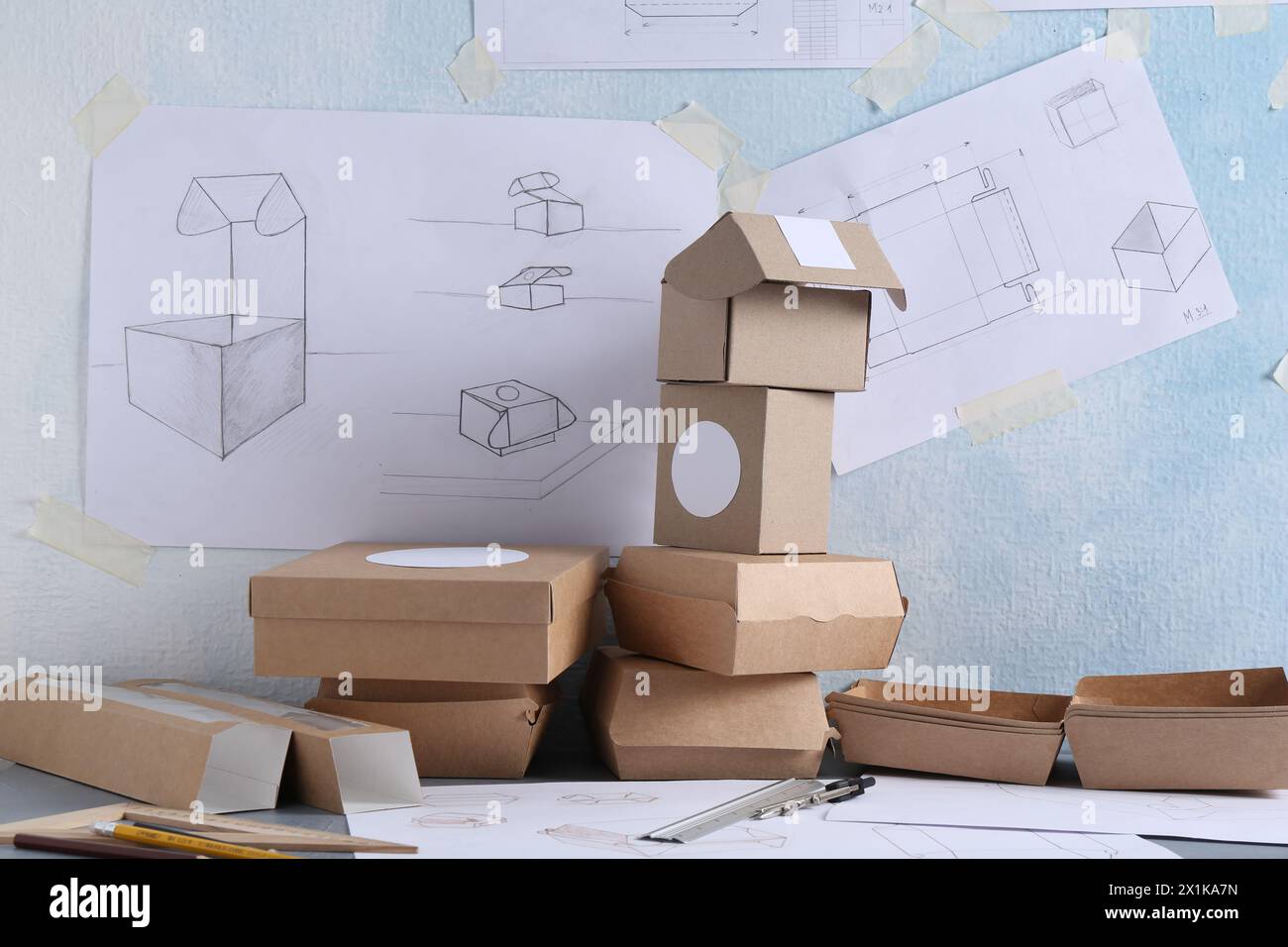 Creating packaging design. Drawings, boxes and stationery on table ...