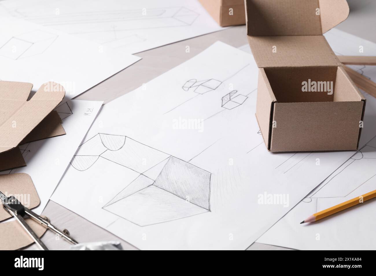 Creating packaging design. Drawings, boxes and stationery on table ...
