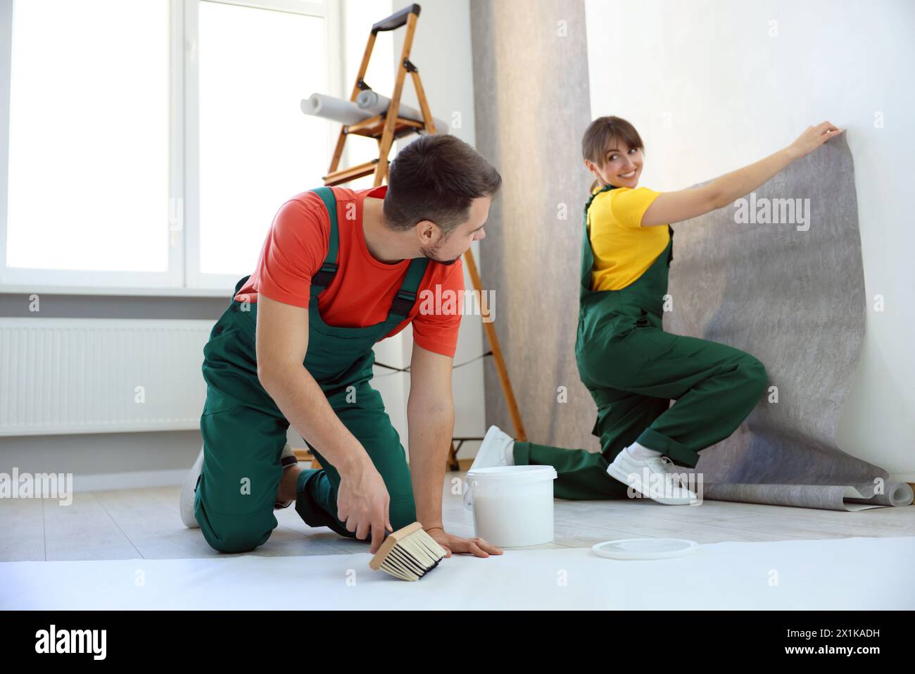 Workers hanging stylish gray wallpaper in room Stock Photo - Alamy