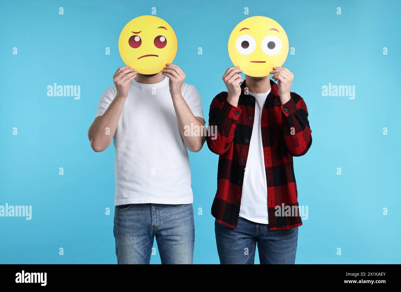 People covering faces with emoticons on light blue background Stock ...
