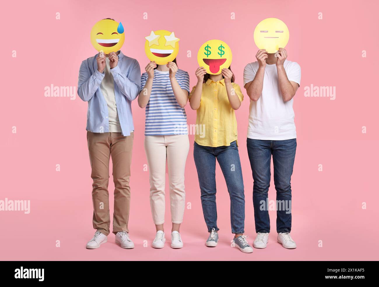 People covering faces with emoticons on pink background Stock Photo - Alamy