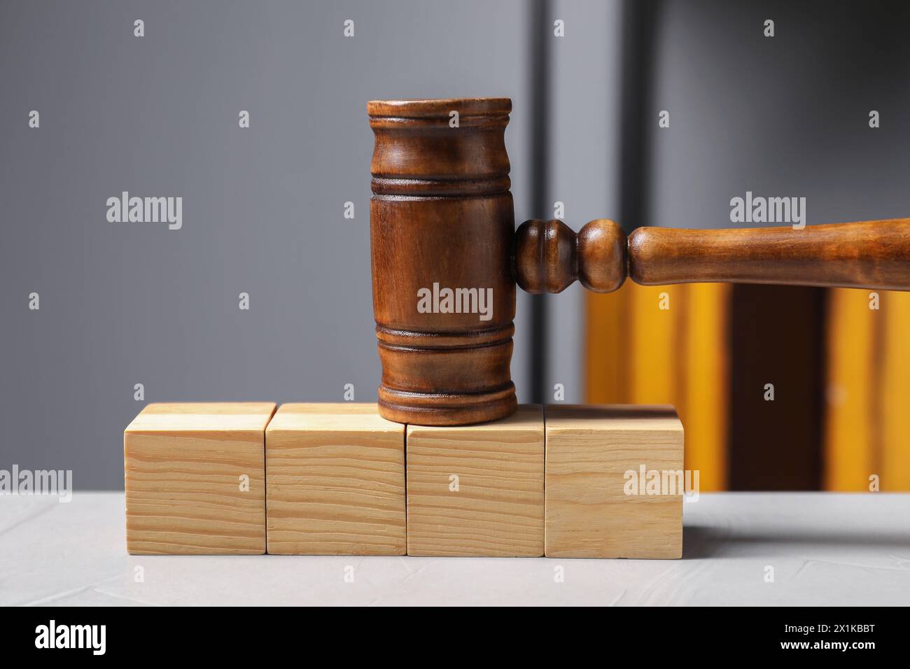 Law. Blank wooden cubes and gavel on light table against gray ...