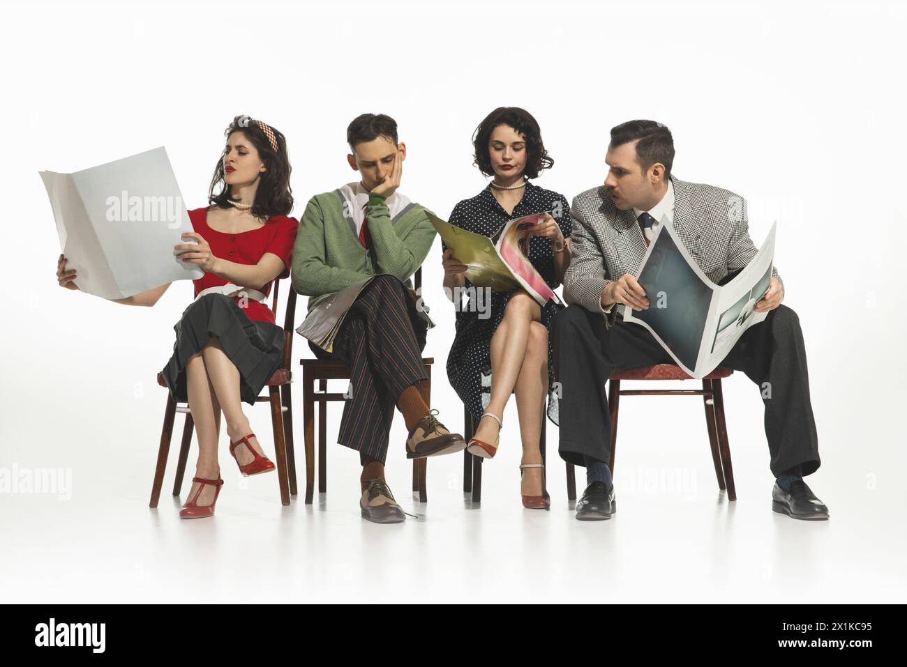 Group of four people, men and women in retro-style clothes sitting on ...