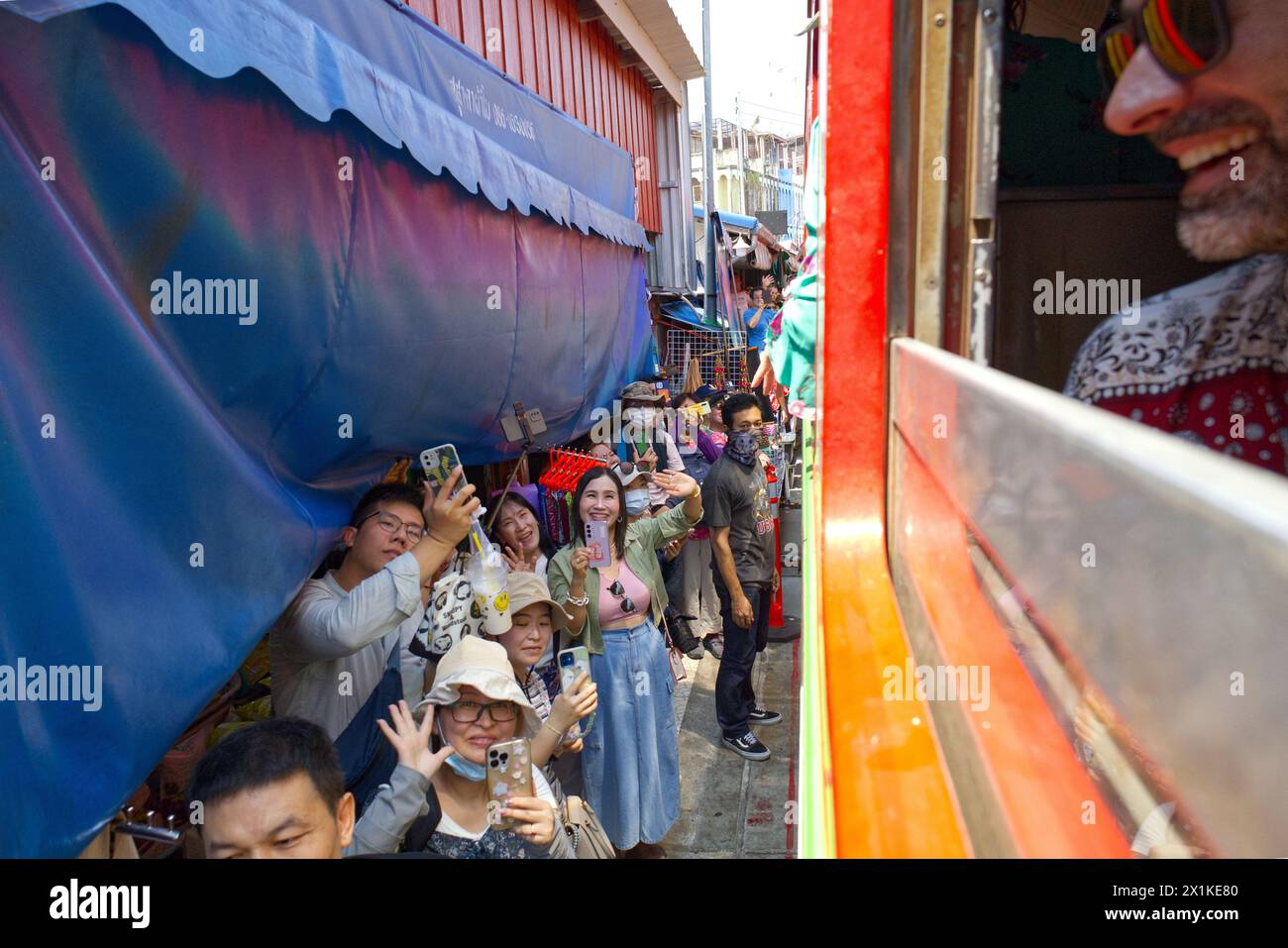 Maeklong, Thailand - Man watches from carriage as people use ...