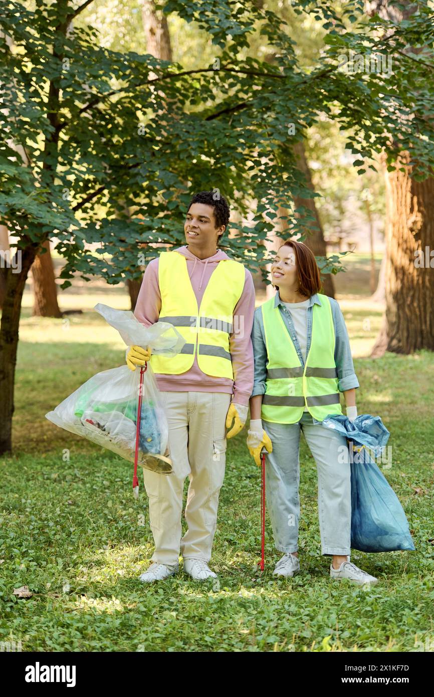 A socially active, diverse couple in safety vests and gloves stand in ...