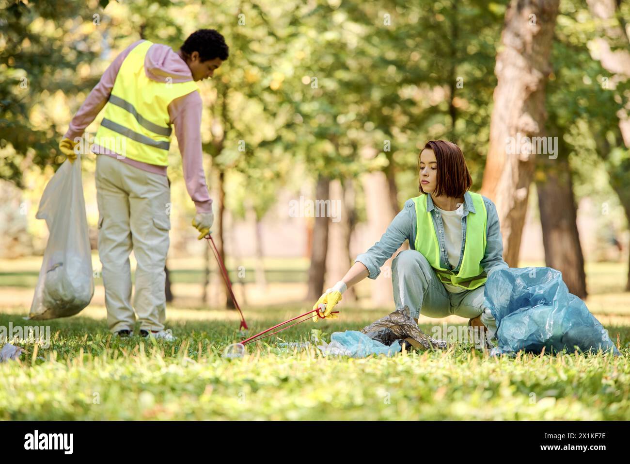 A socially active, diverse couple in safety vests and gloves cleaning ...