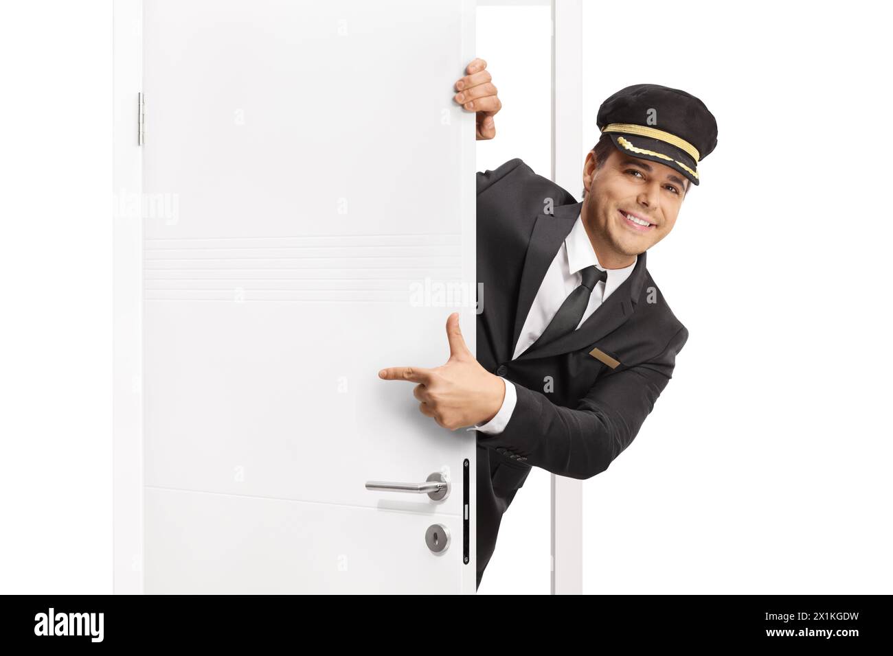 Smiling man in a uniform and hat standing behind a door and pointing ...