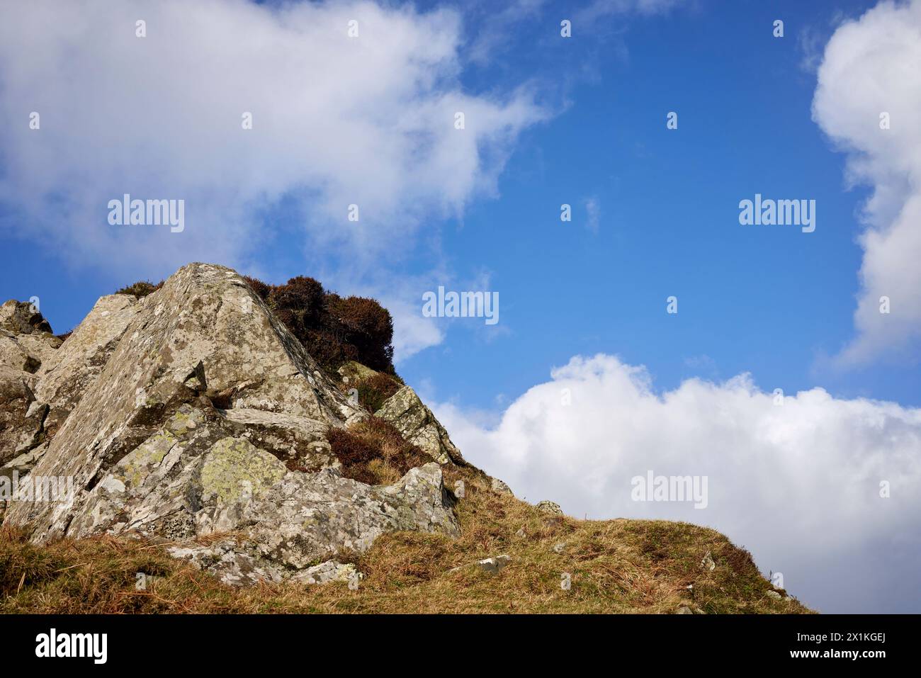 A rocky outcrop against a blue sky with white clouds at Craignish Point ...