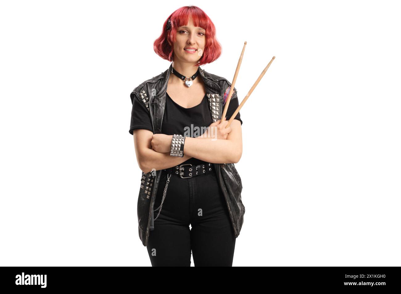 Young female rock drummer standing and holding a pair of drumsticks ...